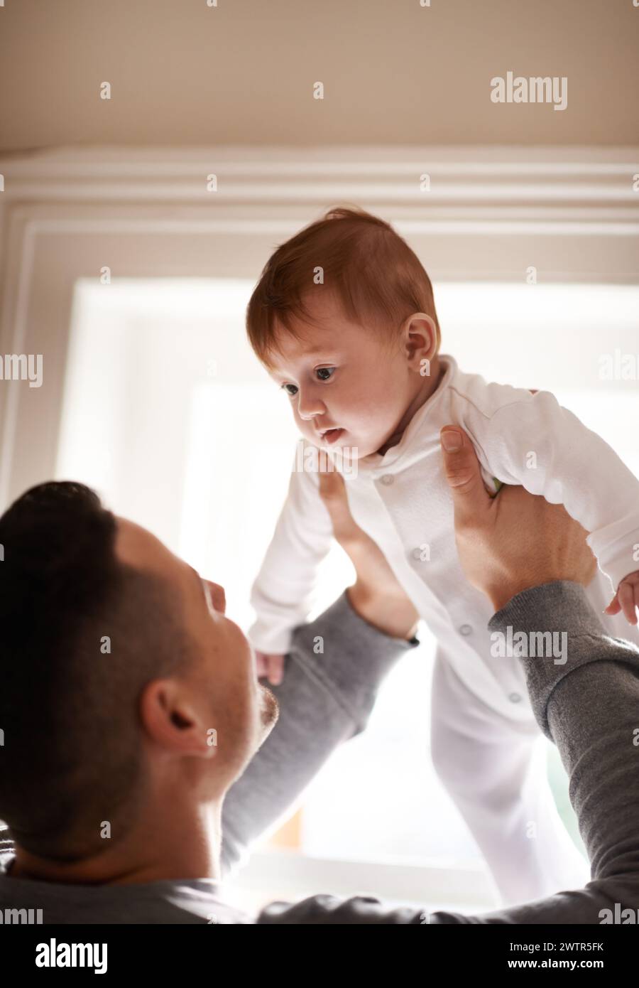 Love, hug or father lifting baby in a house with care, trust and child ...