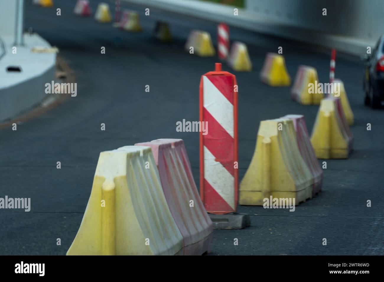 Red, white plastic safety barriers along road. Ensuring road safety ... Red, white plastic safety barriers along road. Ensuring road safety ...