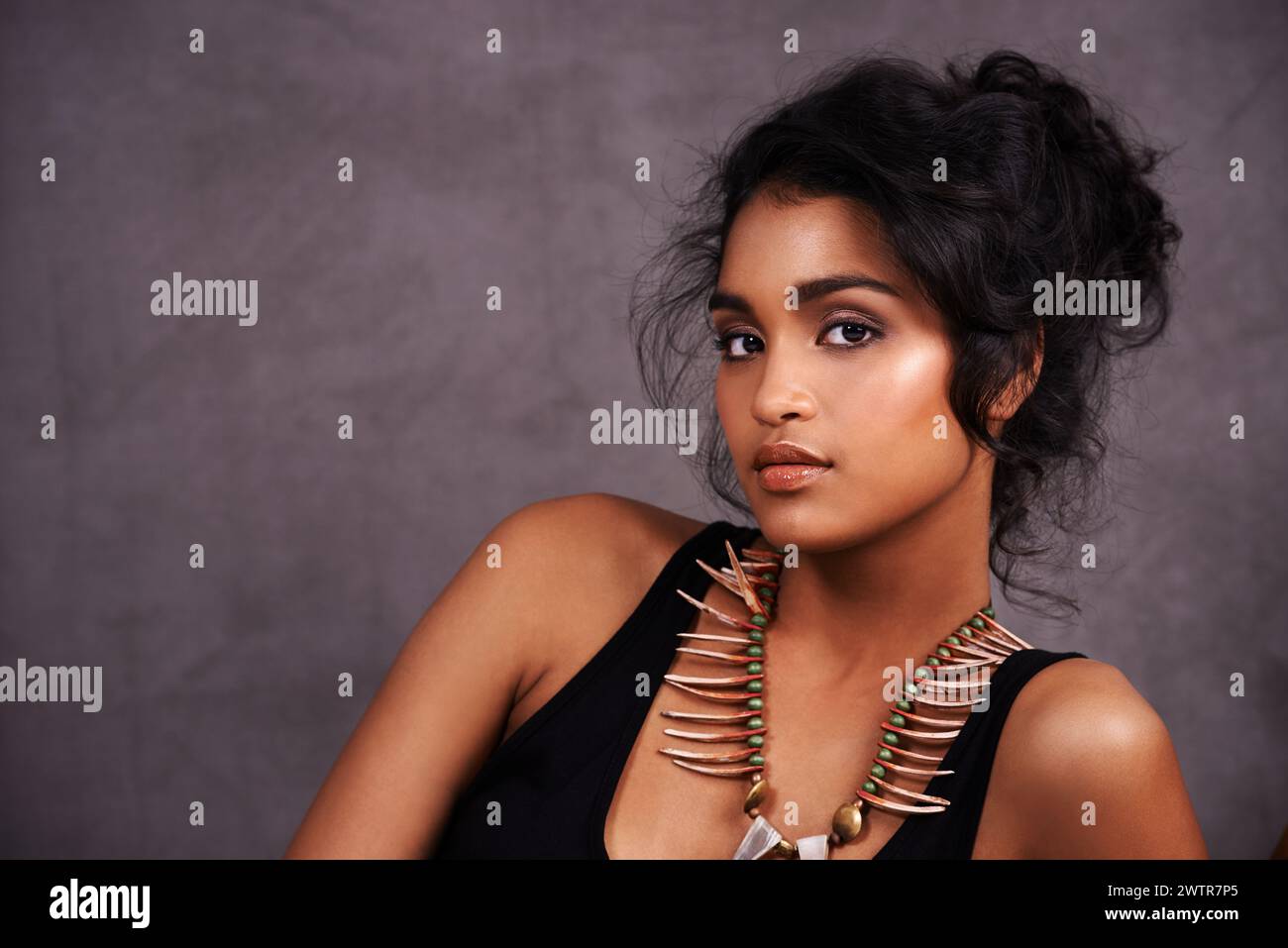 Indian woman, confident and fashion with jewelry in studio on grey ...