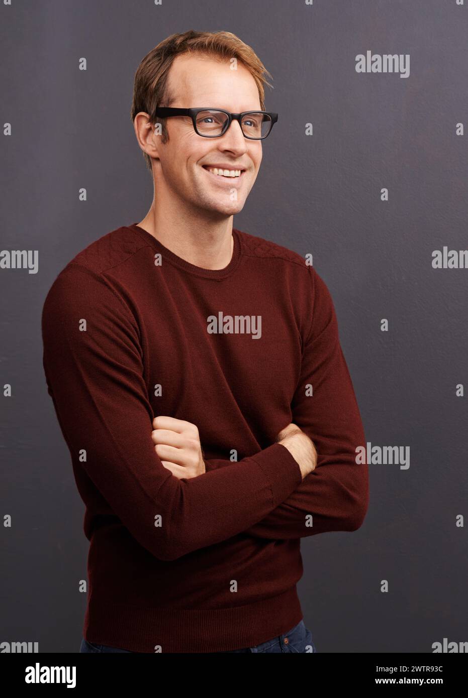 Man, thinking and happy nerd in studio with arms crossed and ...