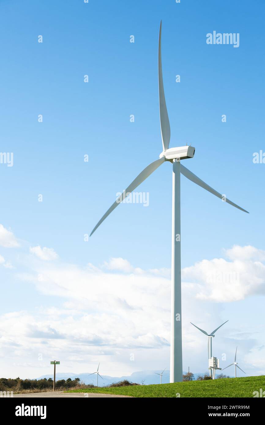 big wind turbine with its big blades and blue sky in the background ...