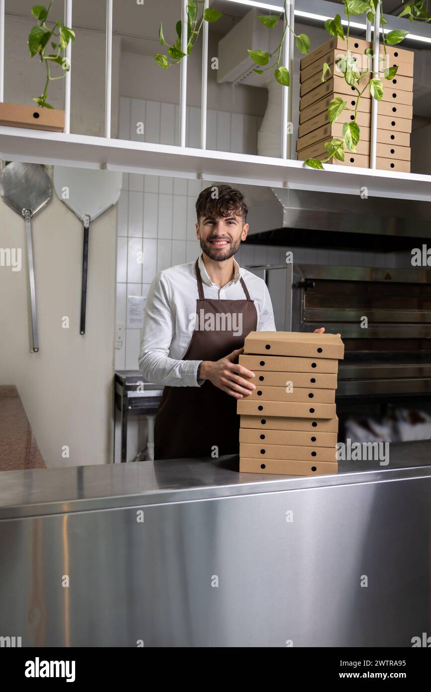 Bearded man cafe employee holding stack of pizza boxes Stock Photo - Alamy