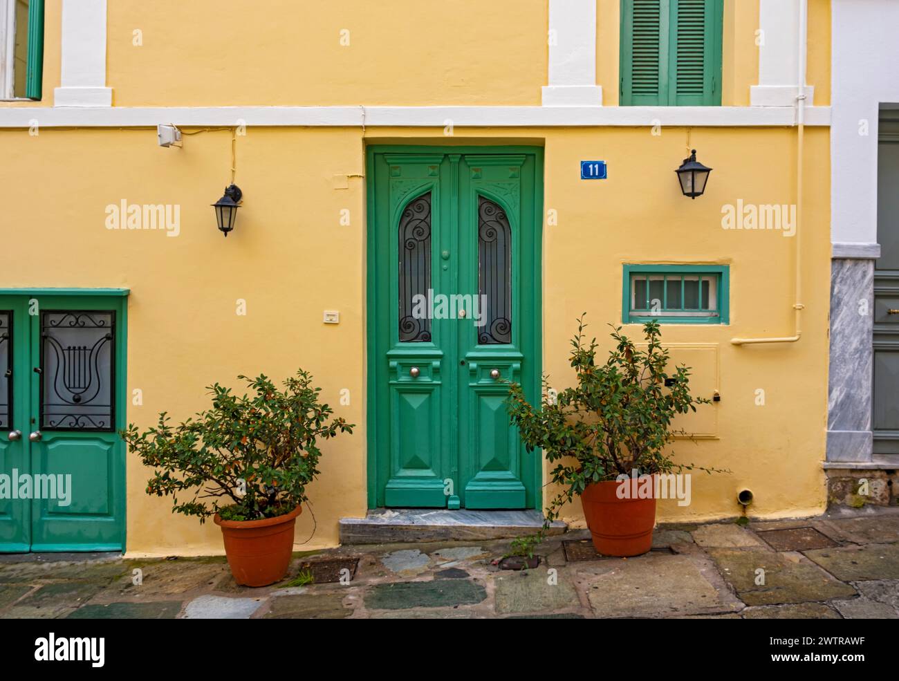 A charming house with a yellow facade and green doors in the Plaka ...