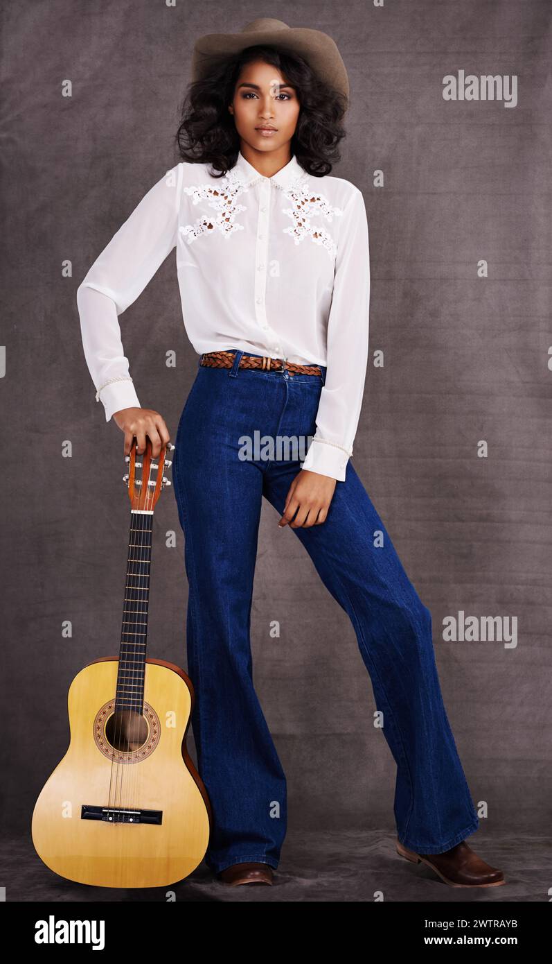 Woman, fashion and musician cowgirl in studio, western clothing and ...