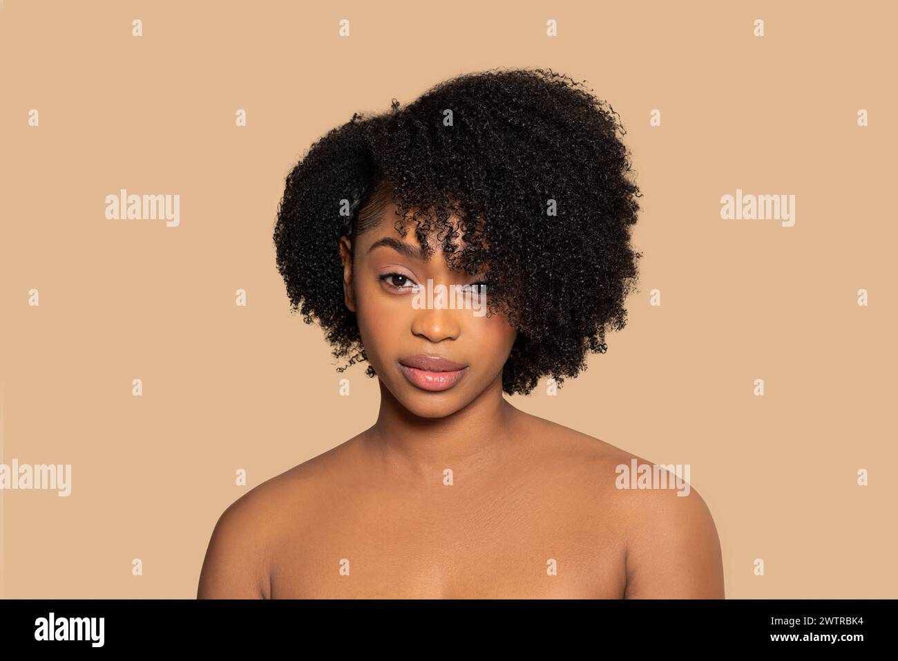 Confident black woman with bushy hair on beige backdrop Stock Photo - Alamy