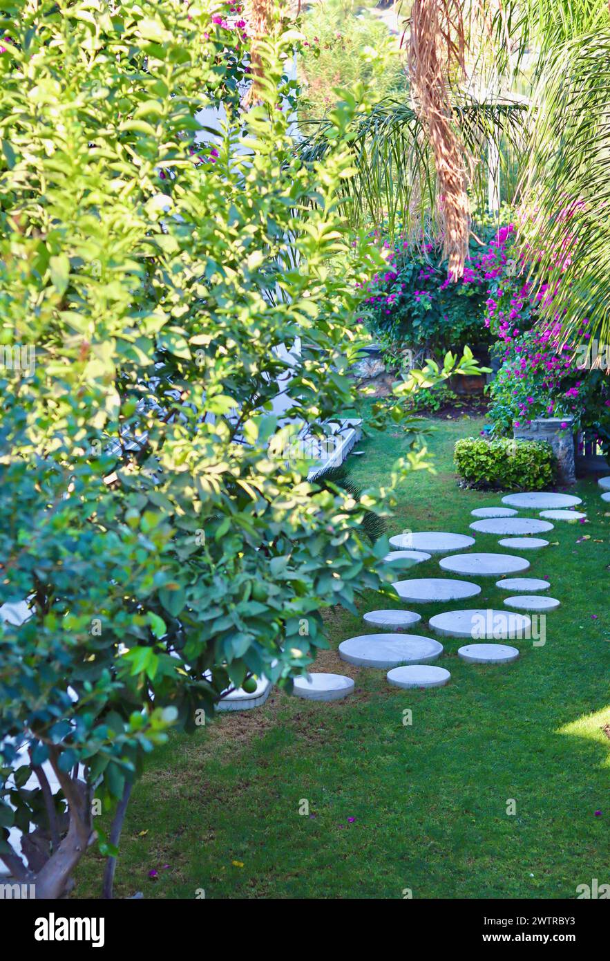Round white marble walkway with black gravel in the garden of a house ...