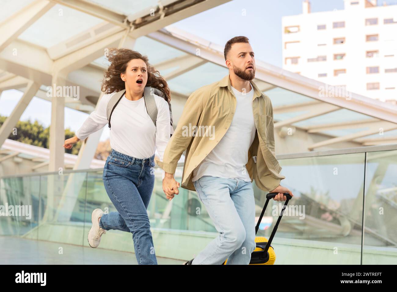 Stressed young couple running in airport terminal, late for their ...