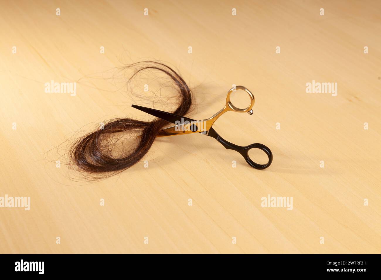 Hair cuttings beside scissors on a table Stock Photo - Alamy