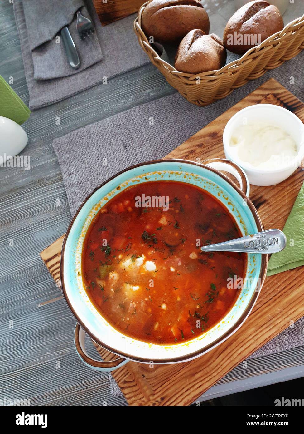 Borscht in a handmade tureen on a wooden table in a cafe. A national ...