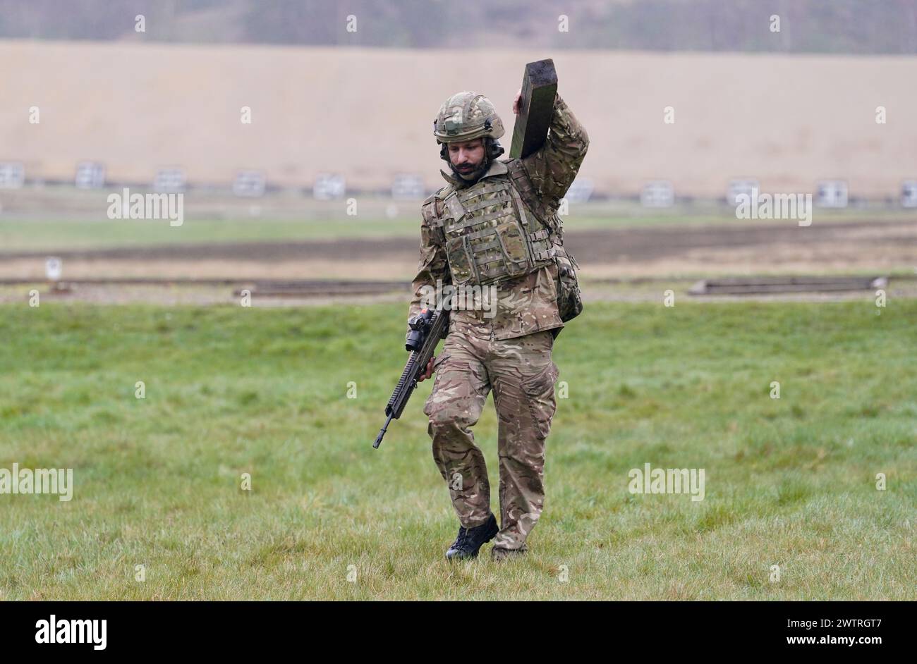 A Sikh soldier of the British Army carries a shooting post as he makes ...