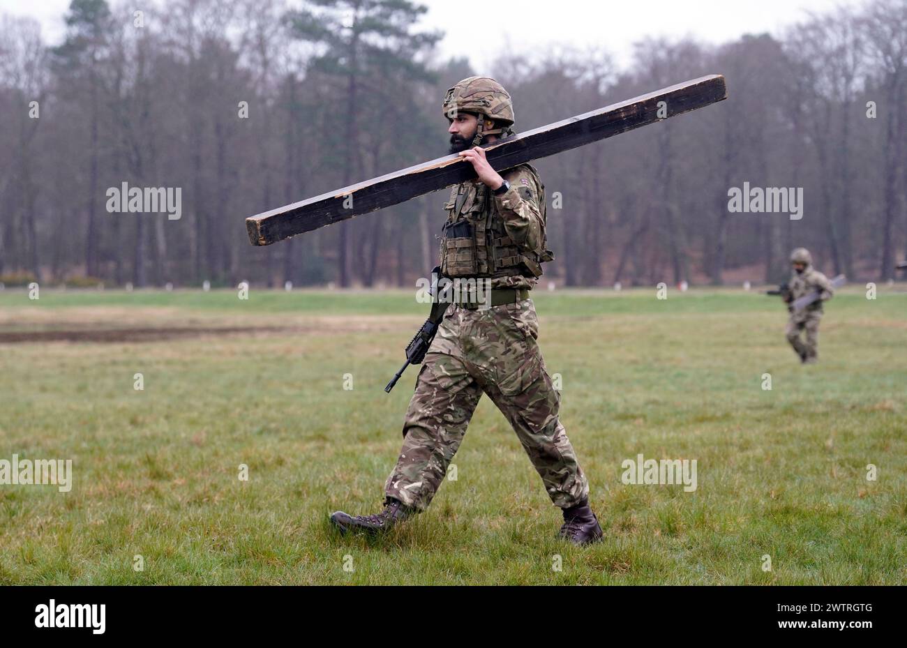 A Sikh soldier of the British Army carries a shooting post as he makes ...