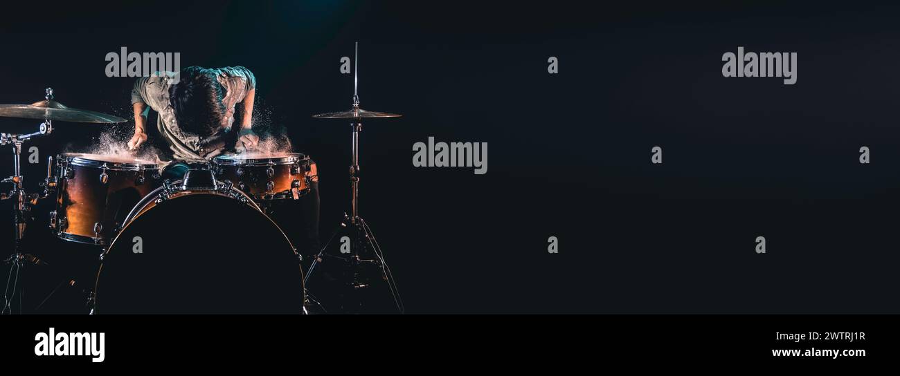 Professional drummer playing on drum set on stage on the black ...
