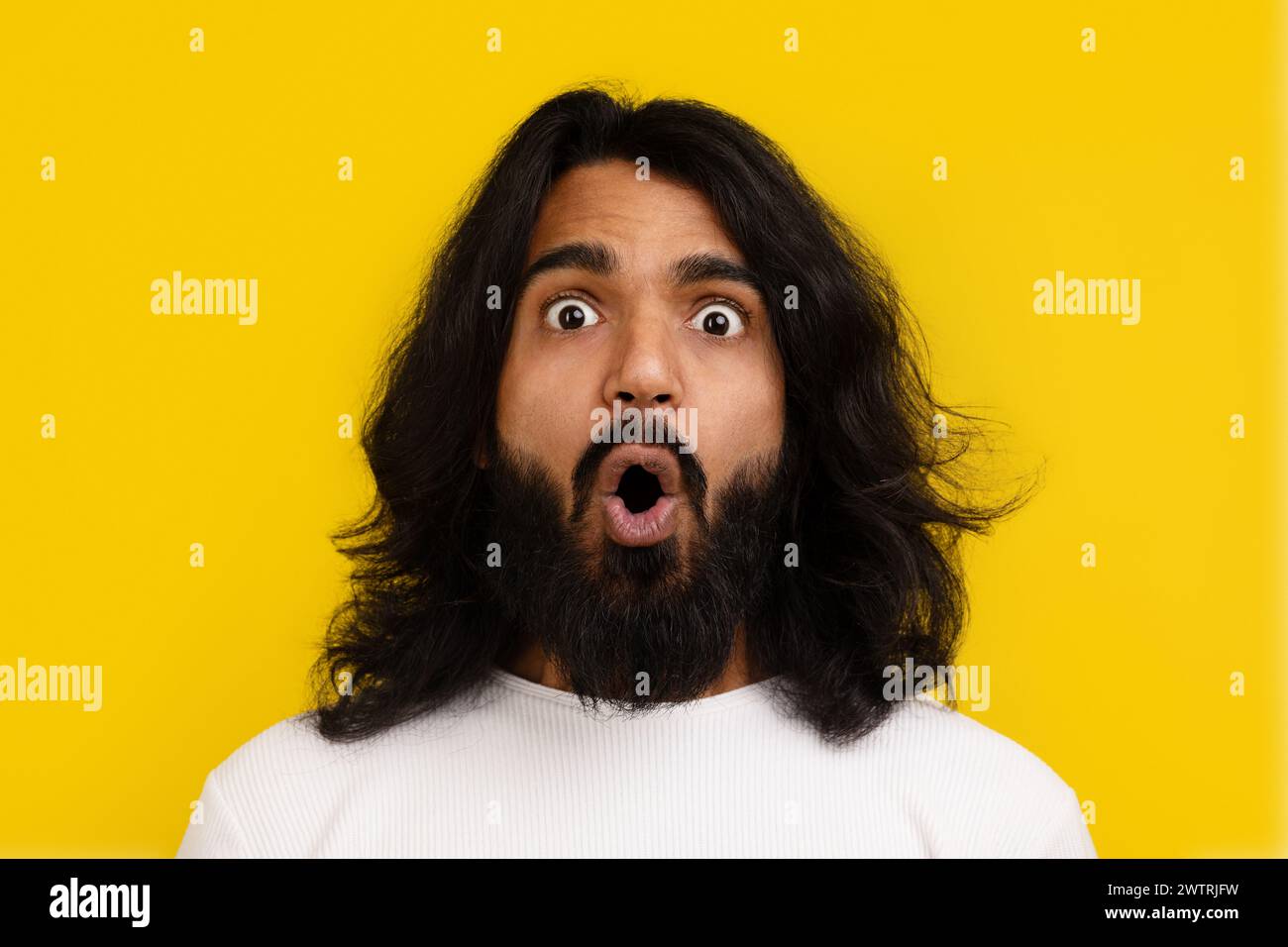 Portrait of shocked indian guy posing on yellow studio background Stock ...
