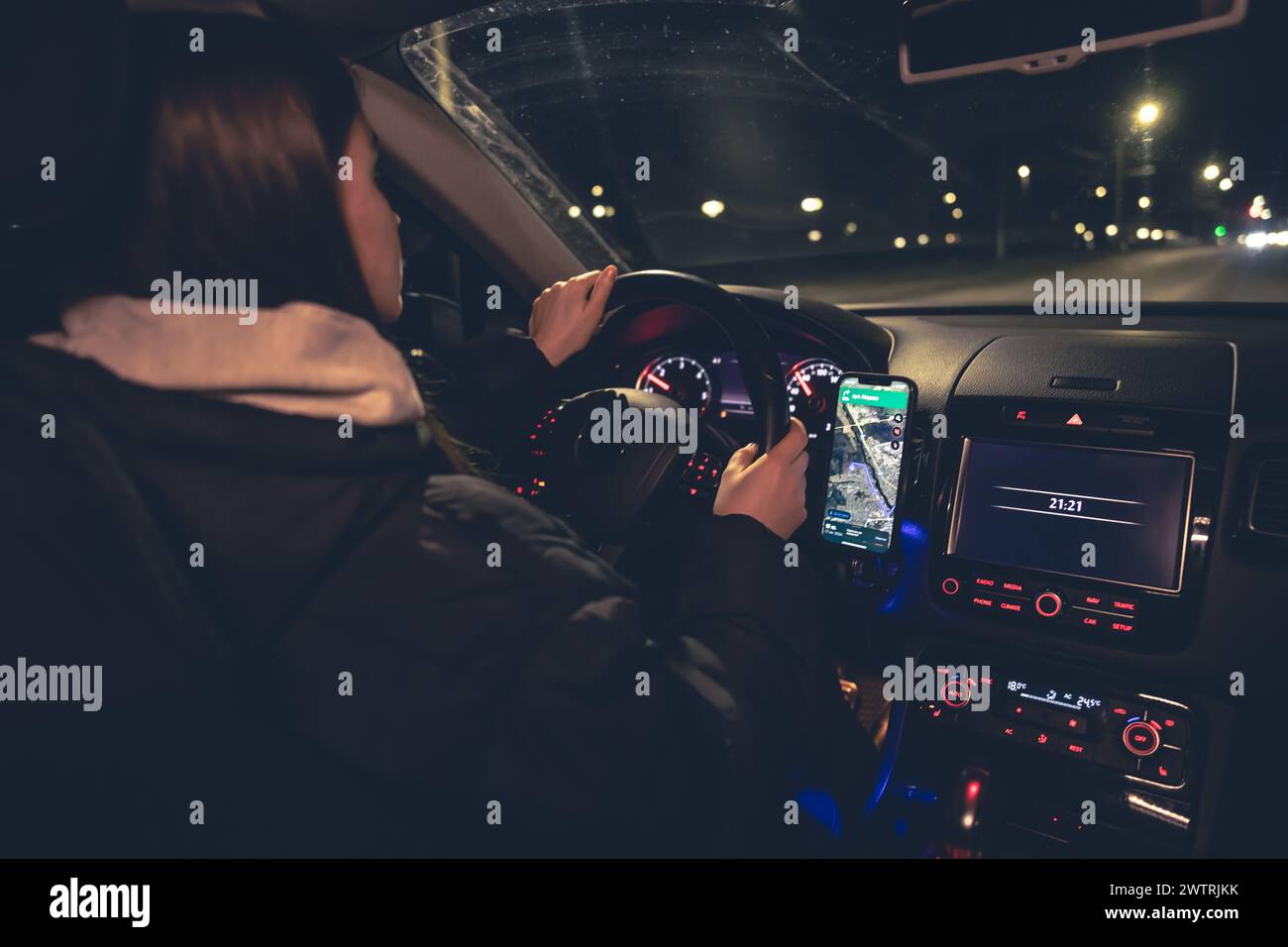 Driving a car at night, a woman driving her modern car at night in the ...