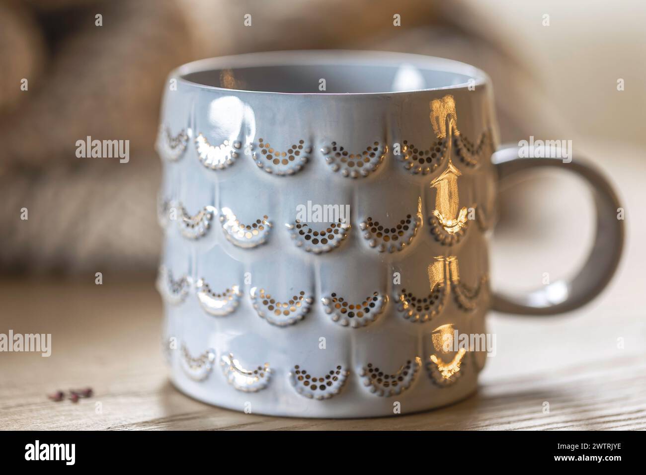 Close-up, shiny gray cup on a blurred background with a knitted element ...