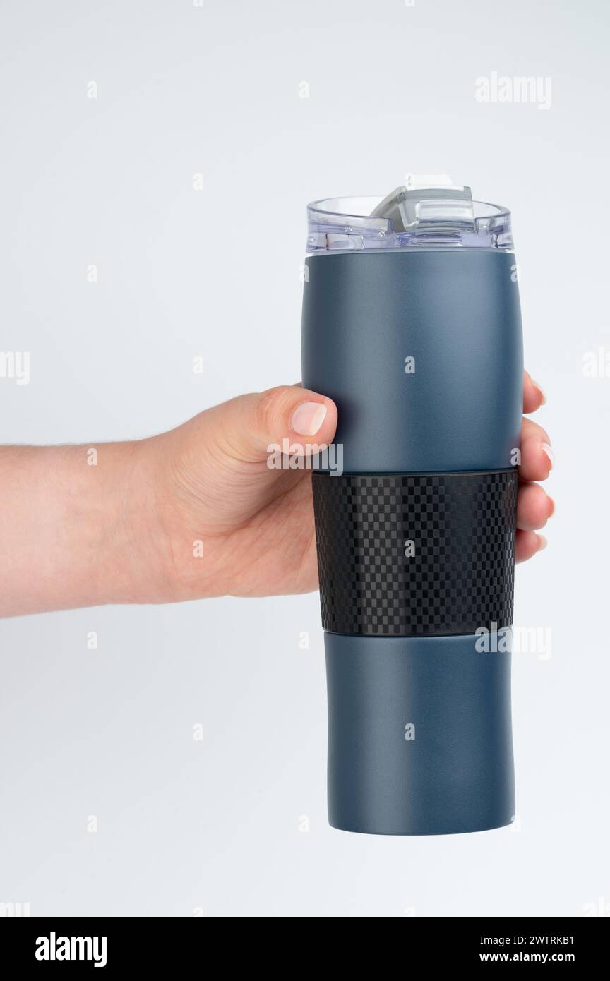 Blue metal flask in hand side view isolated on white studio background ...