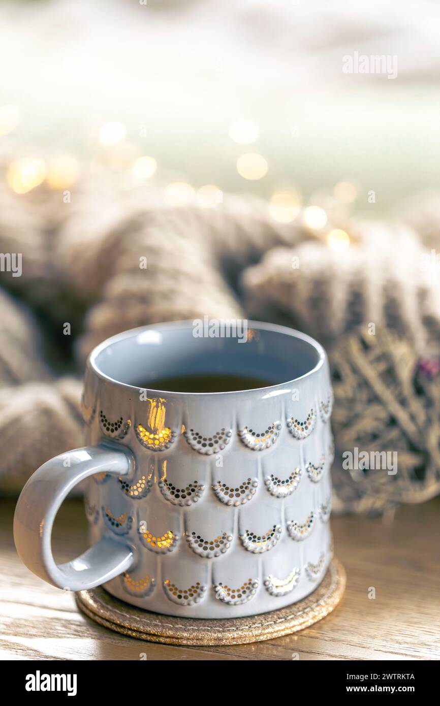 Close-up, shiny gray cup on a blurred background with a knitted element ...