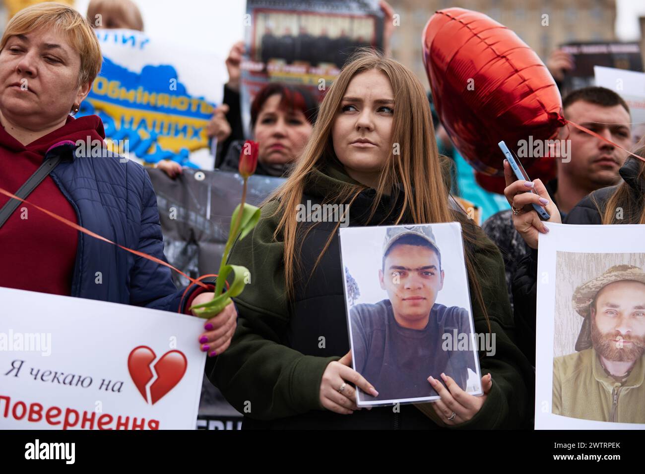 Young Ukrainian woman holds a banner with her relative, the serviceman ...