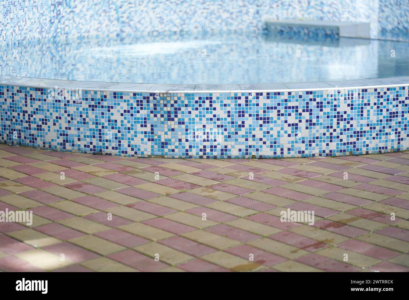 Side view of an outdoor swimming pool with blue and white mosaic ...