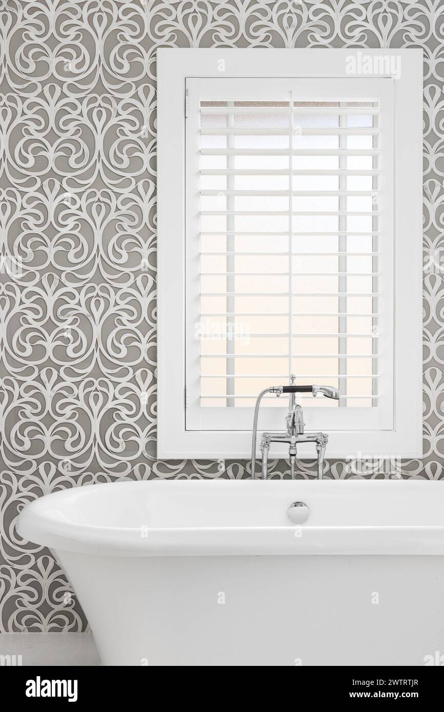 A freestanding soaking tub detail with a grey and white tile pattern ...