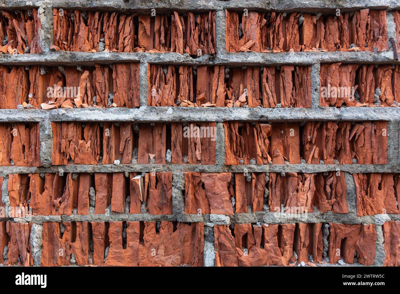 A wall of cracked red brick from the bad weather. Old crumbling ...