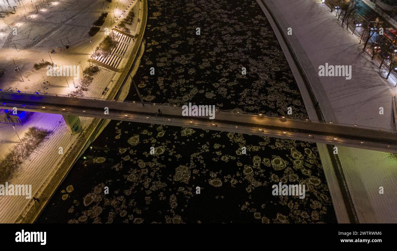 Drone photography of iced up river, bridge and people walking during ...