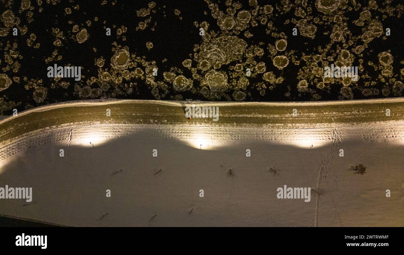 Drone photography of iced up river, footpath beside it and people ...