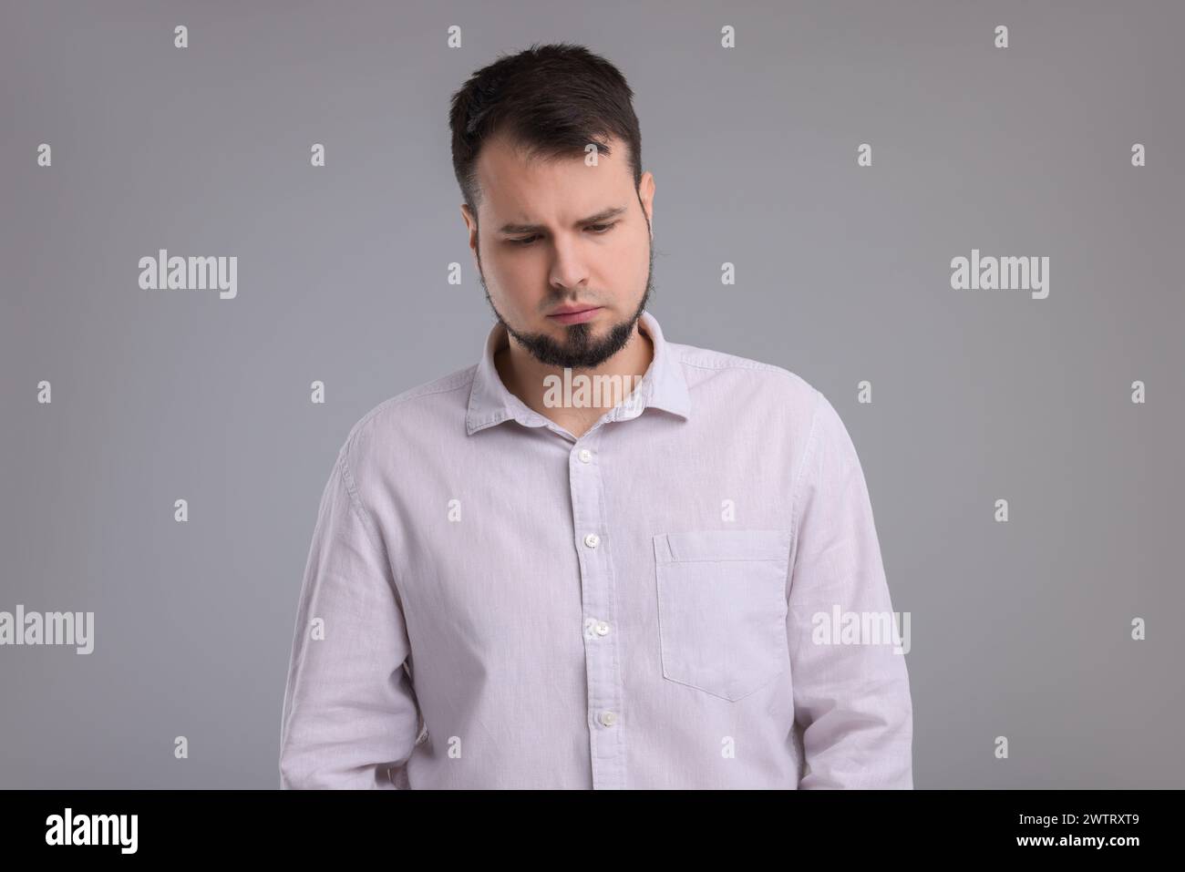 Portrait of sad man on grey background Stock Photo - Alamy
