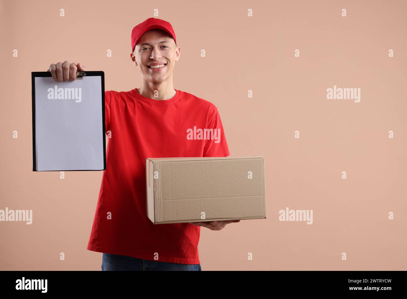 Happy courier with parcel on beige background. Space for text Stock ...