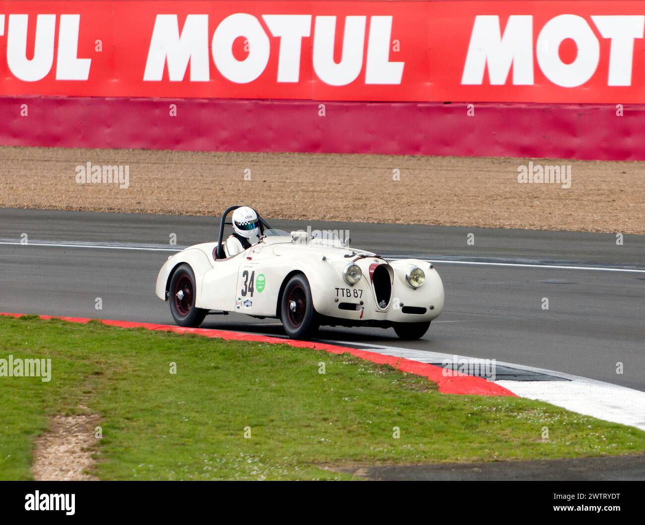 Christopher Scholey driving his White, 1954, Jaguar XK120, in the ...