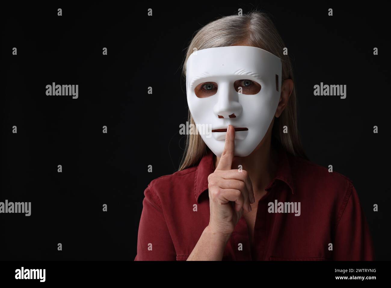 Multiple personality concept. Woman in mask showing hush gesture on ...