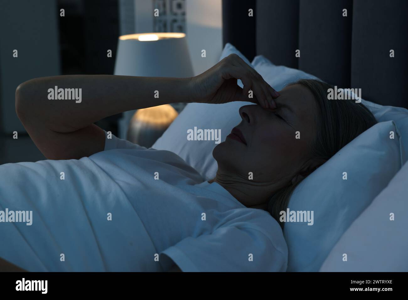 Woman suffering from headache in bed at night Stock Photo - Alamy
