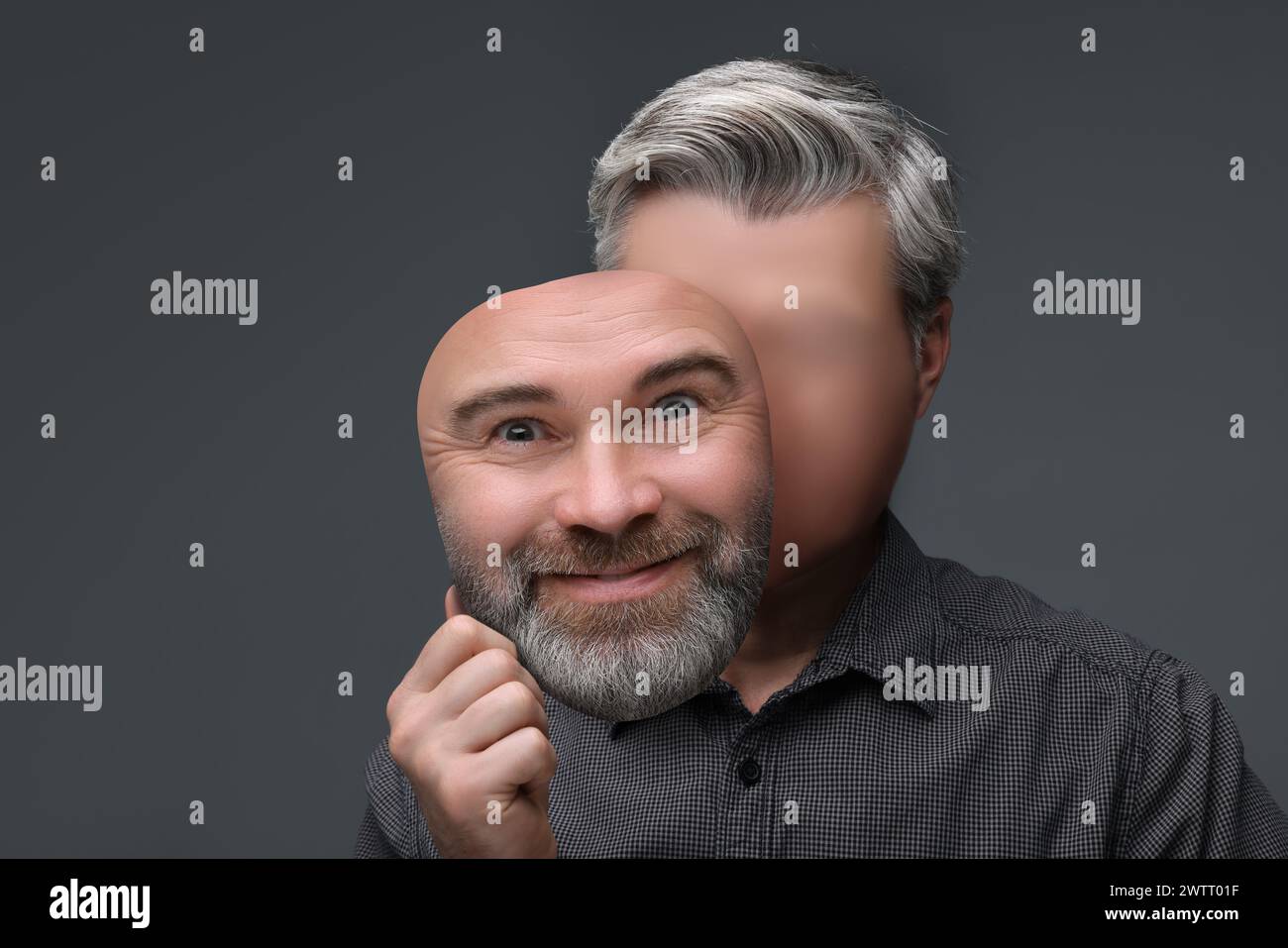 Faceless man holding his face mask showing emotion on grey background ...
