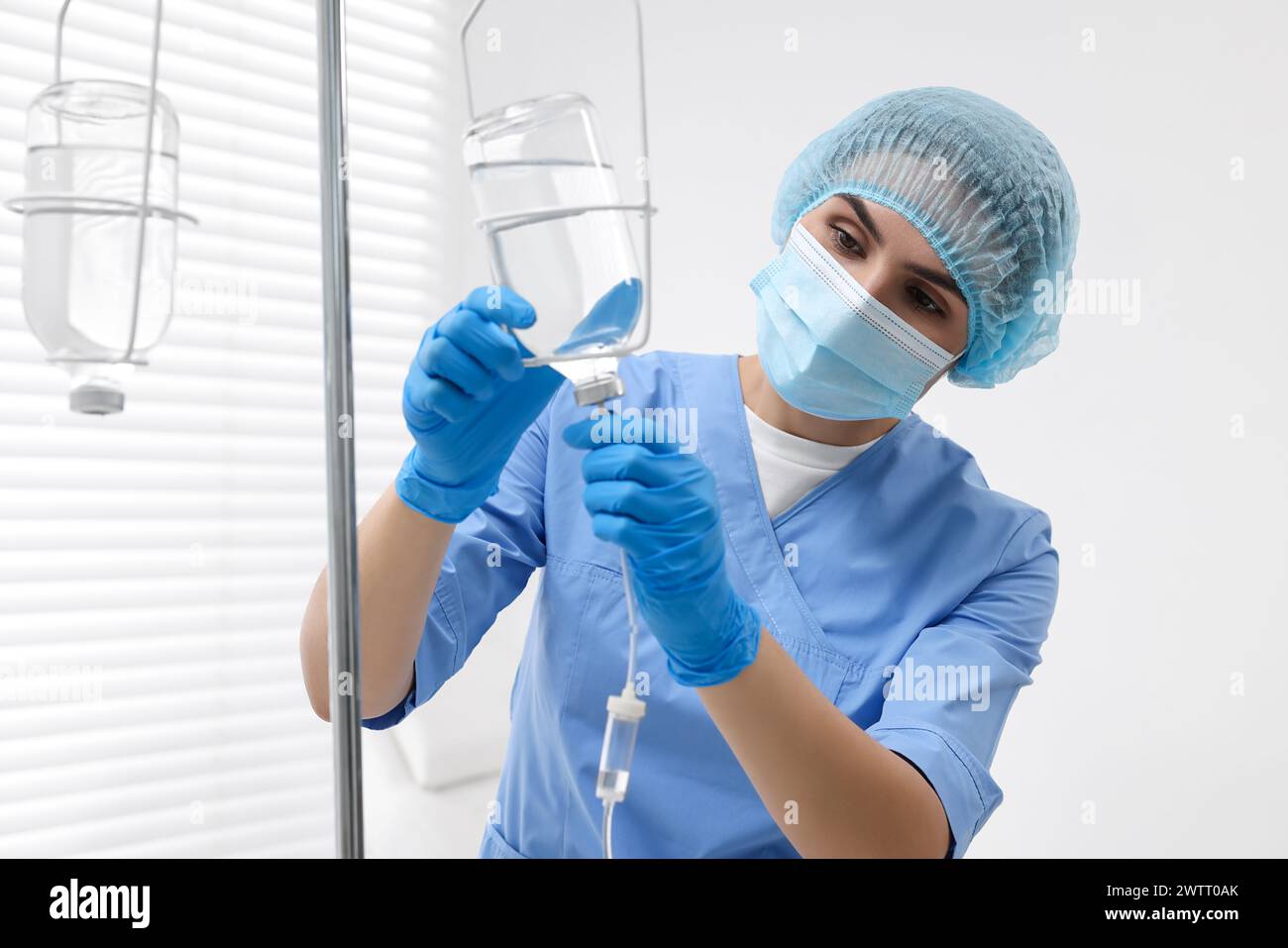 Nurse setting up IV drip in hospital Stock Photo - Alamy