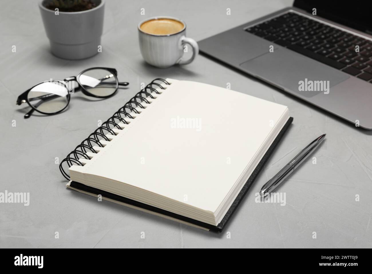 Open notebook, pen, laptop and glasses on light grey table Stock Photo ...