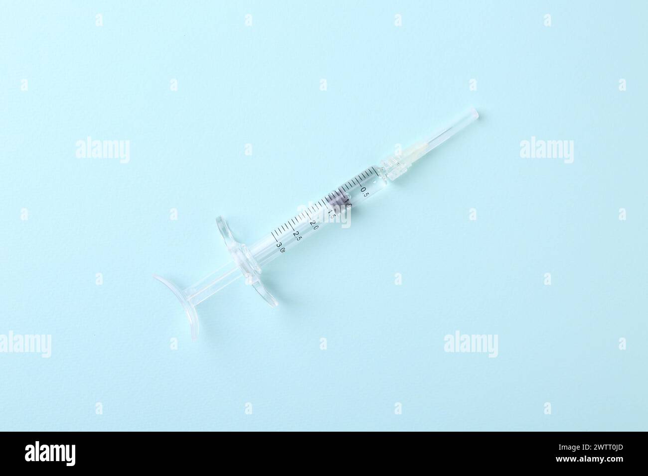 Injection cosmetology. One medical syringe on light blue background ...