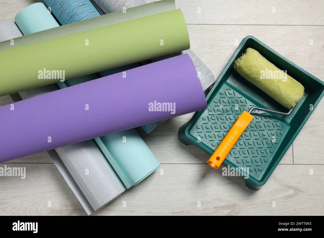 Different wallpaper rolls, roller and tray on floor, top view Stock ...