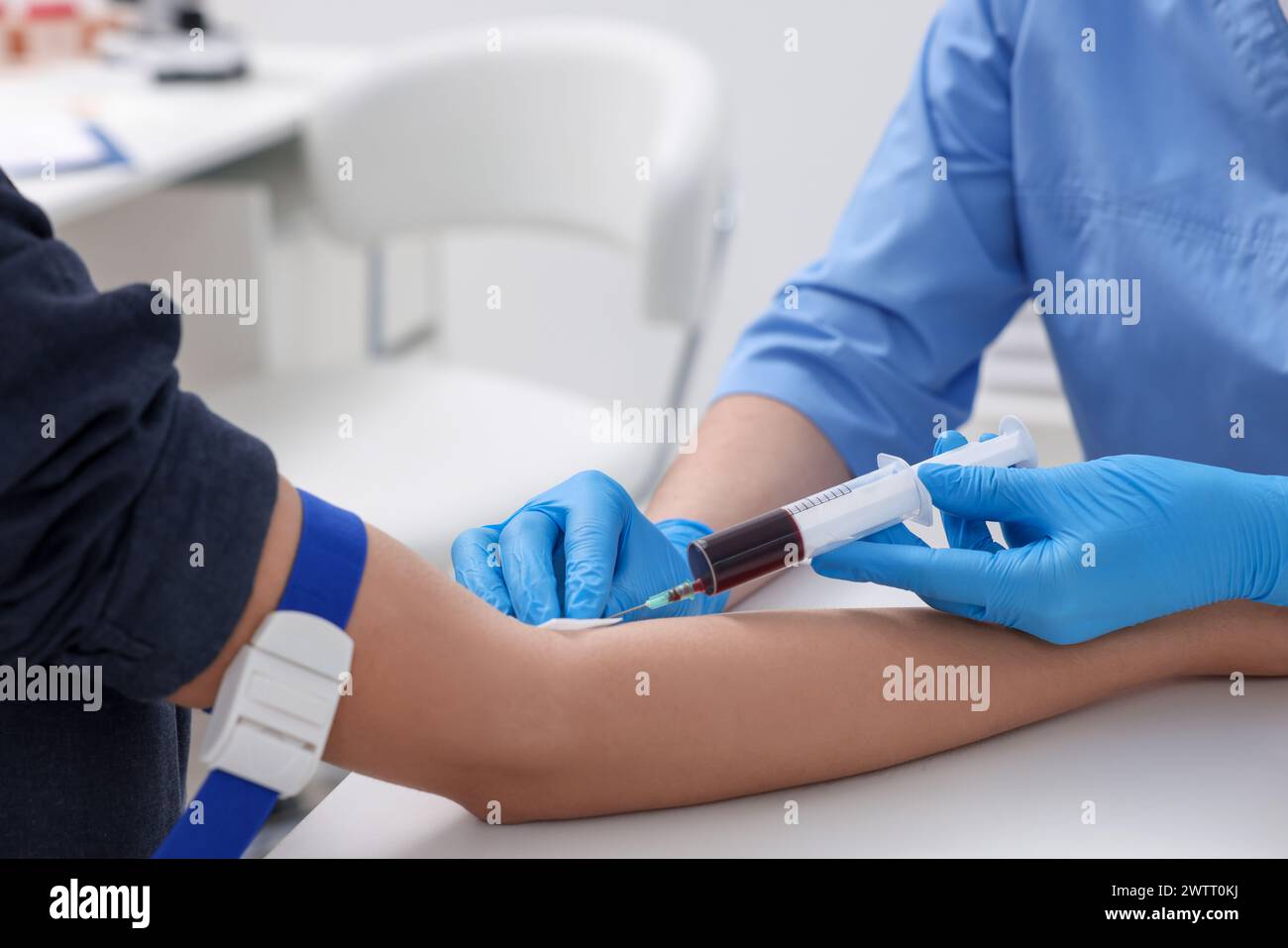 Laboratory testing. Doctor taking blood sample from patient at white ...