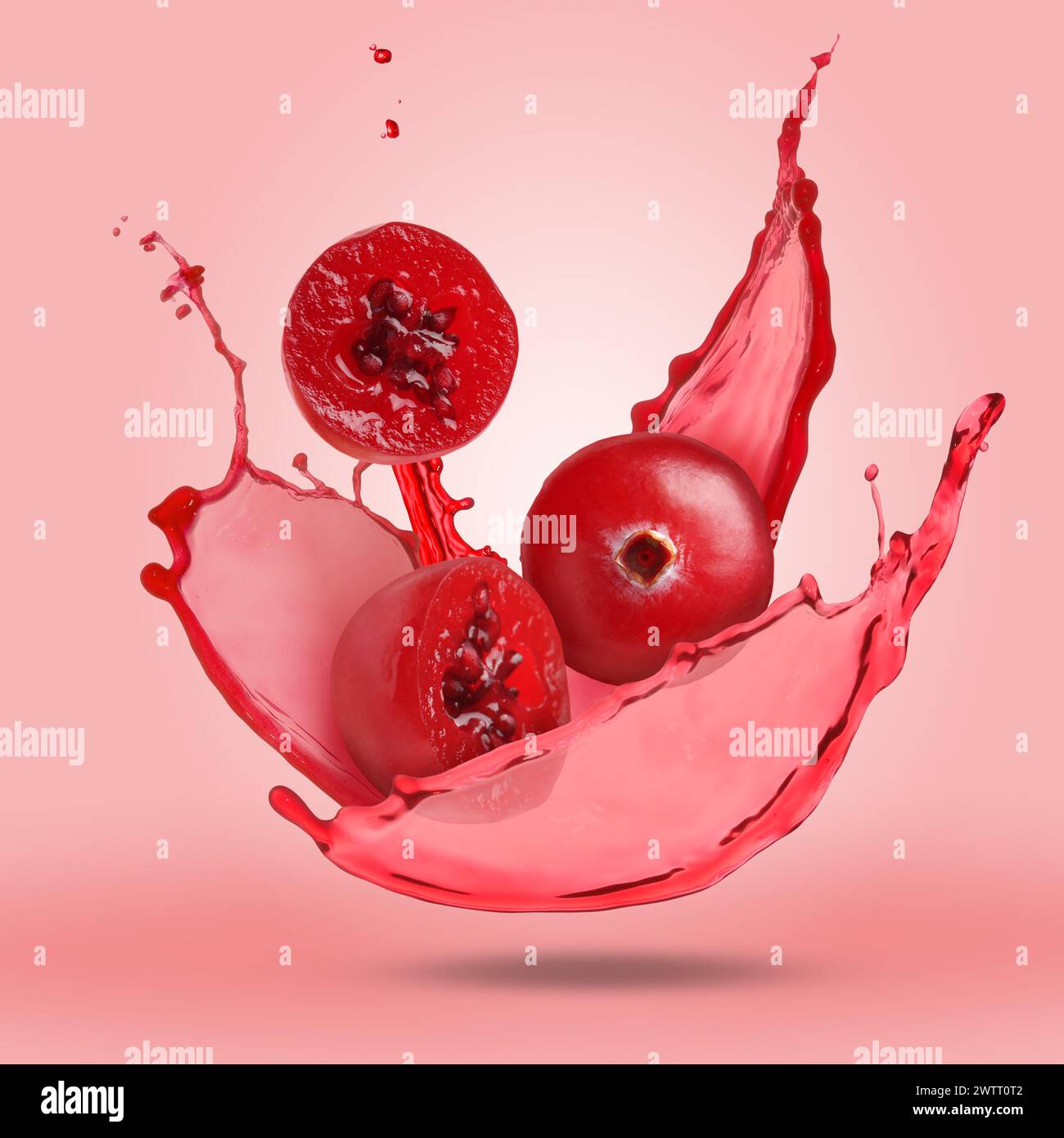 Delicious ripe cranberries and splashing juice in air on pale red ...