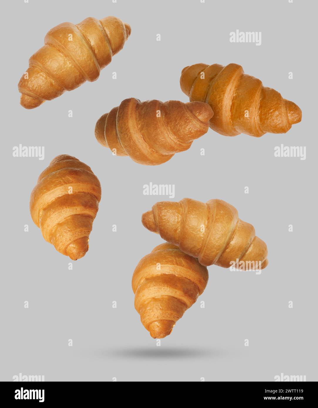 Puff pastry. Fresh croissants falling on grey background Stock Photo ...
