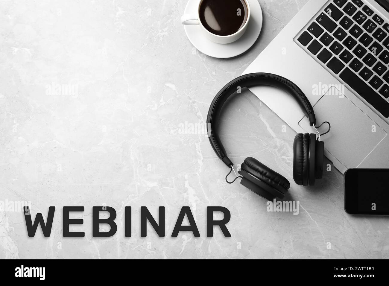 Webinar. Headphones, laptop, coffee and smartphone on grey marble table ...
