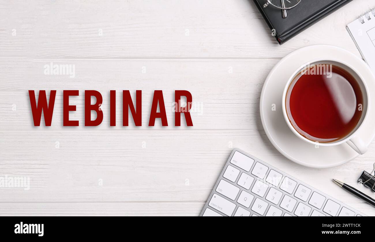 Webinar. Computer keyboard, tea and stationery on white wooden table ...