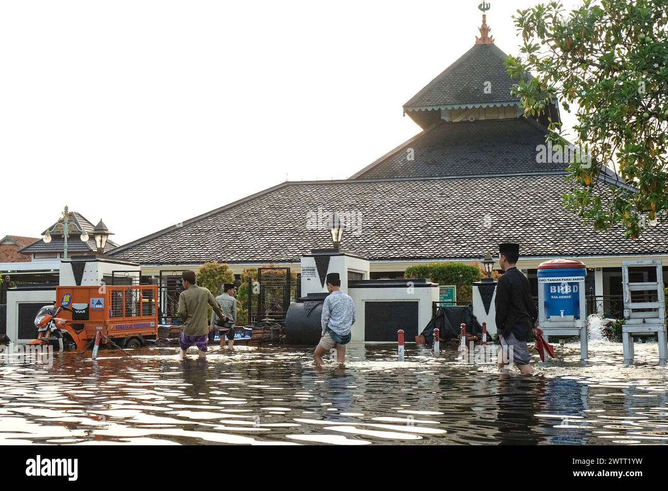 Demak, Indonesia. 19th Mar, 2024. People wade through a flooded-area in ...