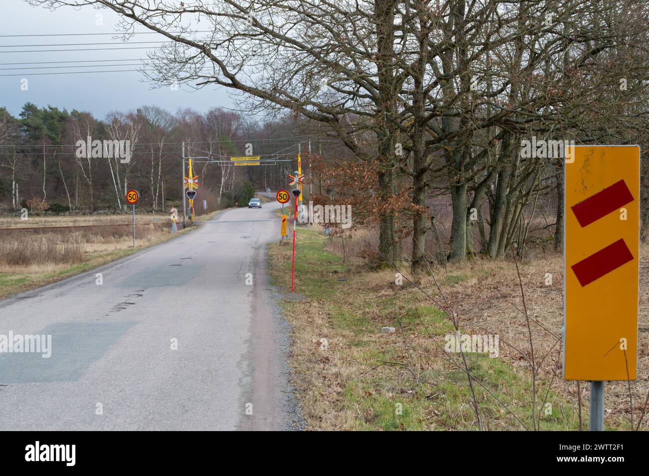 Road with railway crossing and warnings signs and signals Stock Photo ...