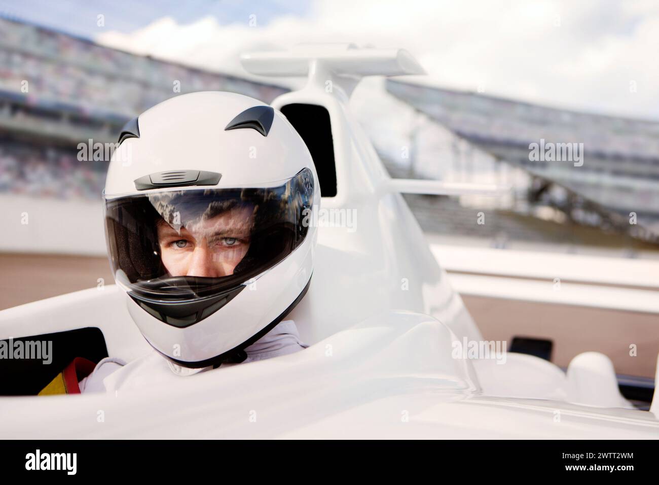 Focused racer ready at the starting line in a white speed machine Stock ...