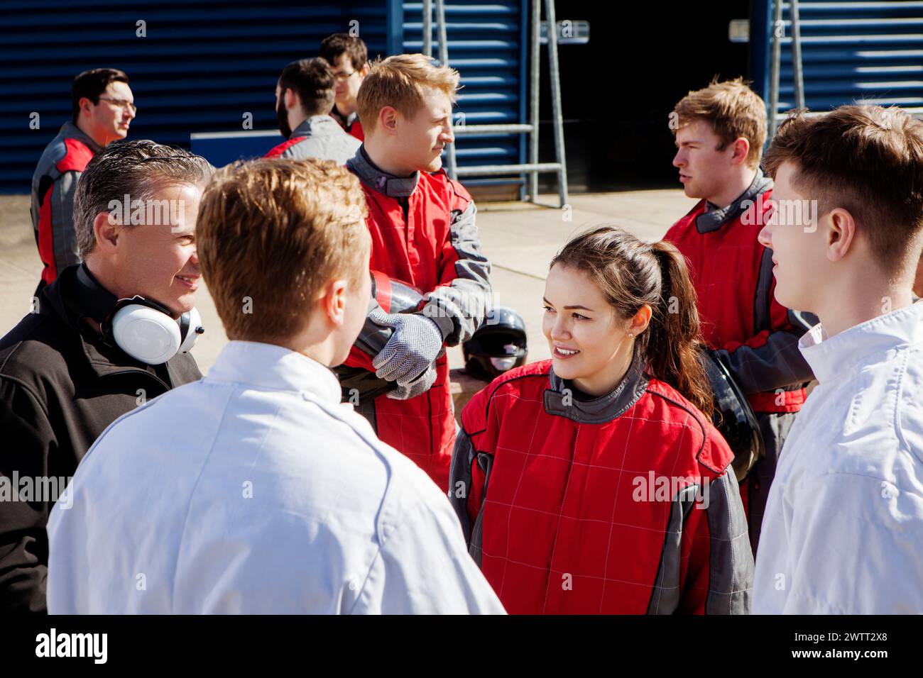 Group of people in racing gear engaging in a conversation Stock Photo ...