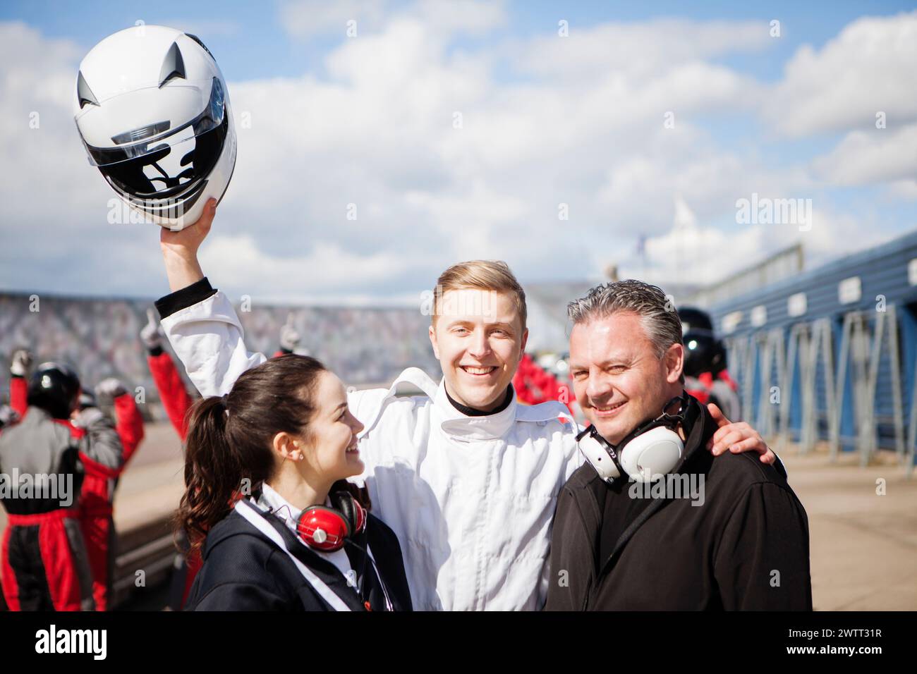 A cheerful group celebrating a successful race track experience under a ...