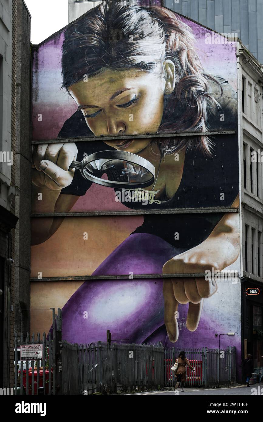 People walk past a mural entitled 'Honey, I shrunk the kids'on the side ...