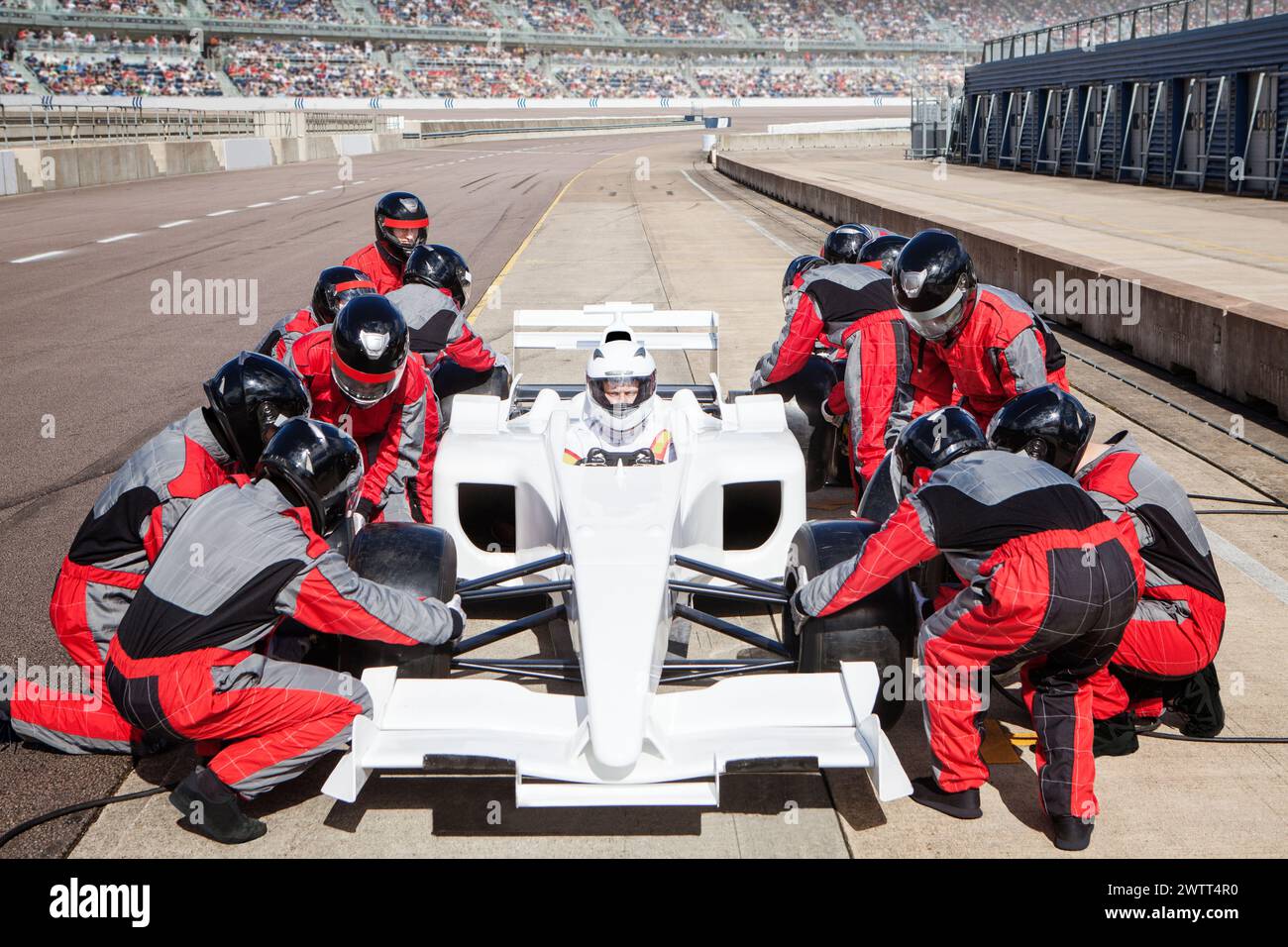 Pit crew in perfect sync servicing a race car on the track Stock Photo ...