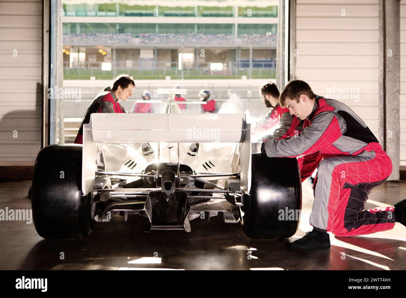 Pit crew team in intense preparation at the race track Stock Photo - Alamy